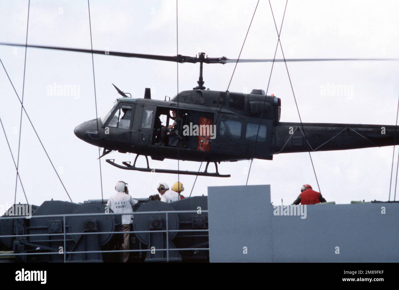 A Marine UH-1N Iroquois helicopter hovers over the flight deck of the ...