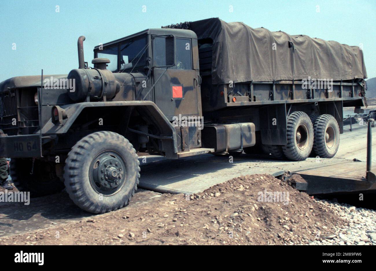 An M814 5-ton cargo truck reaches the shore after crossing a ribbon ...