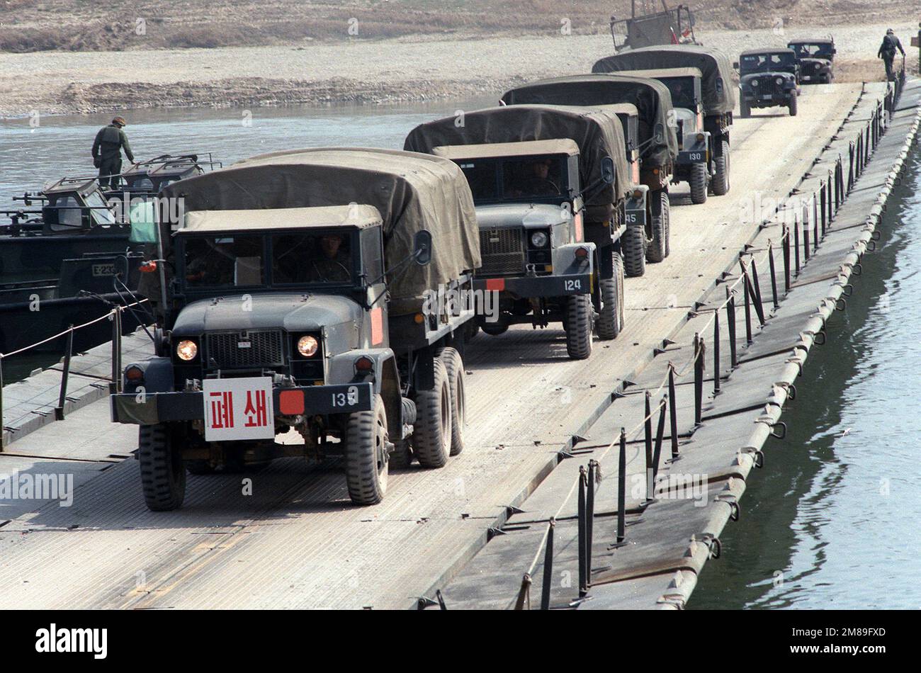 A convoy of South Korean M-35 2.5-ton cargo trucks crosses a ribbon ...