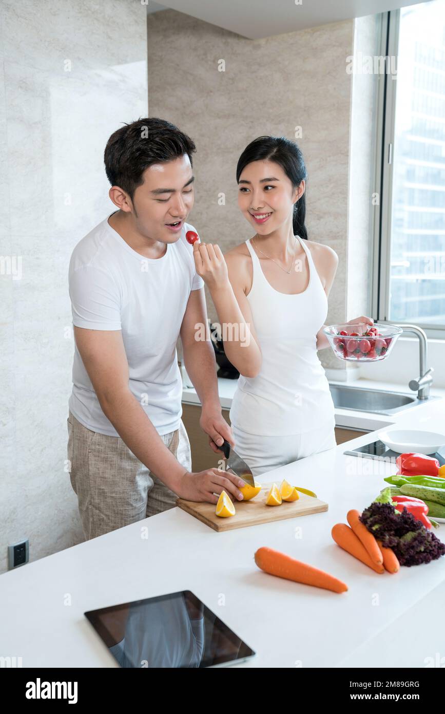 Young couples in the kitchen cooking Stock Photo - Alamy