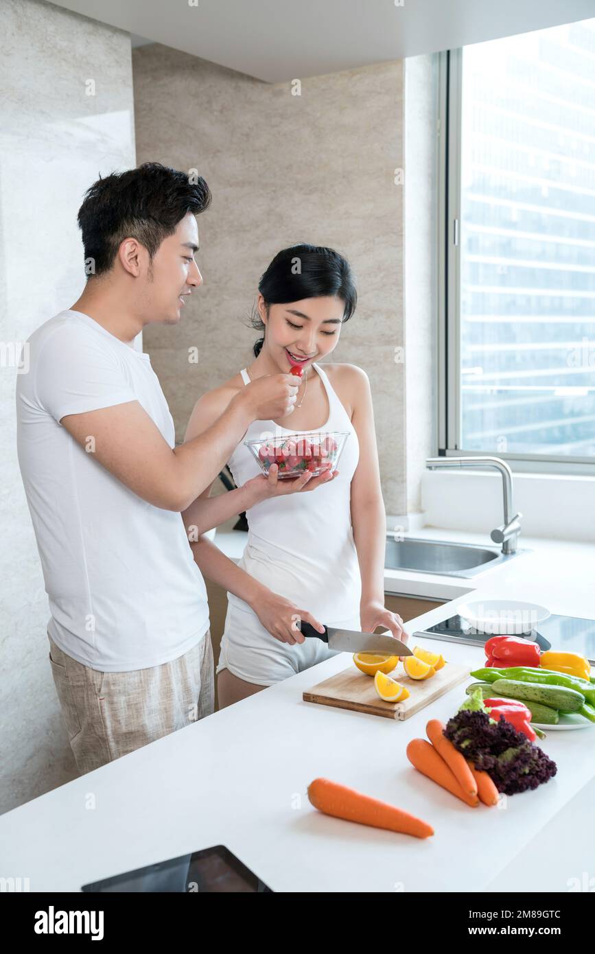 Young couples in the kitchen cooking Stock Photo - Alamy