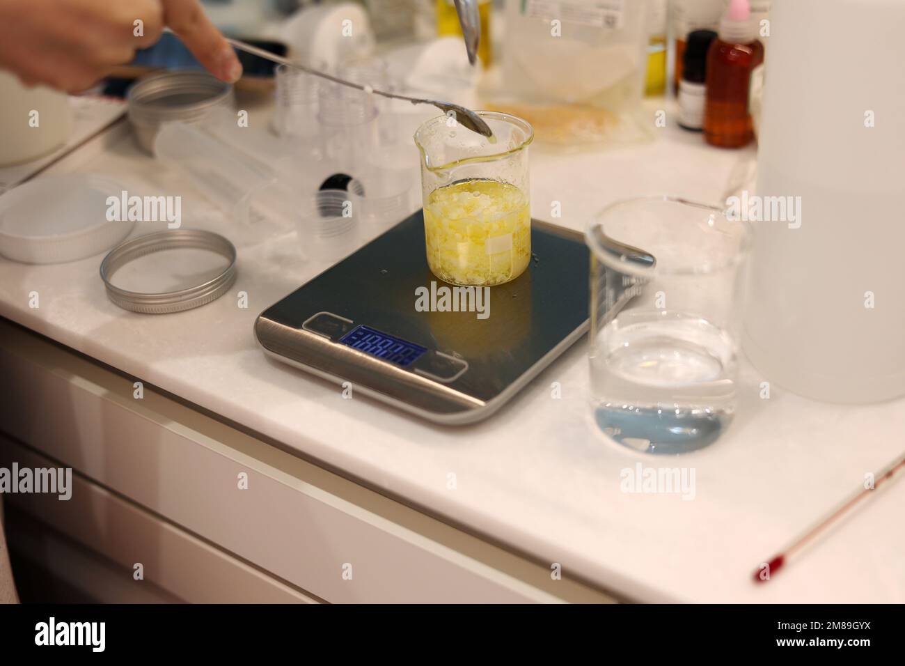 Mix the oil and beeswax in the beaker, weigh ingredients in the beaker ...
