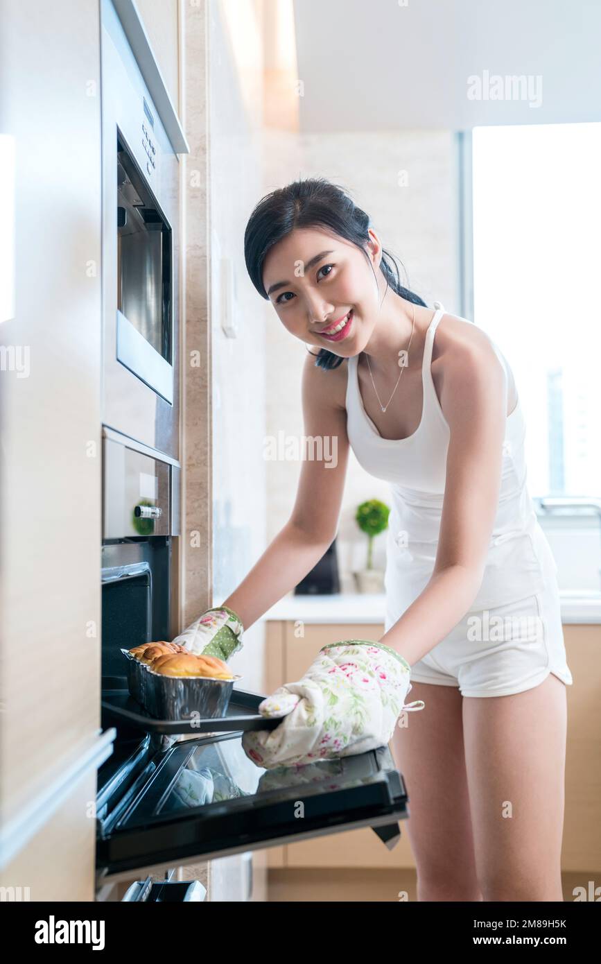 The young woman baking bread in the kitchen Stock Photo - Alamy
