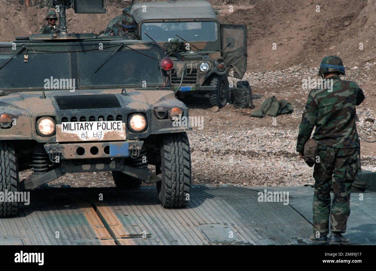 A combat engineer signals for a military police M998 high-mobility ...
