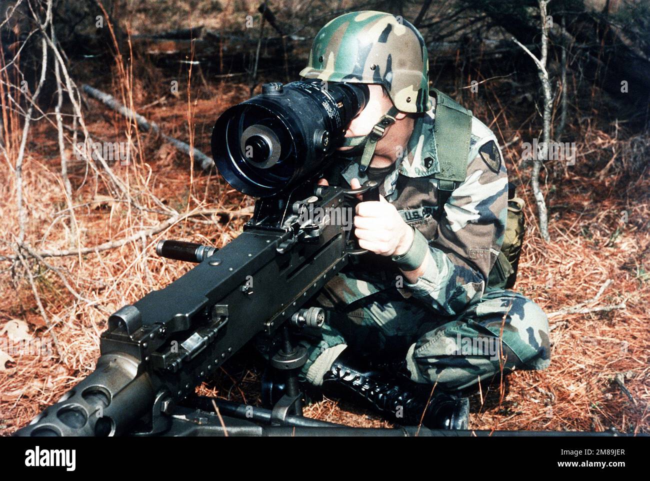A soldier aims an M-2 .50-caliber machine gun equipped with an AN/TVS-5 crew-served weapon sight ...