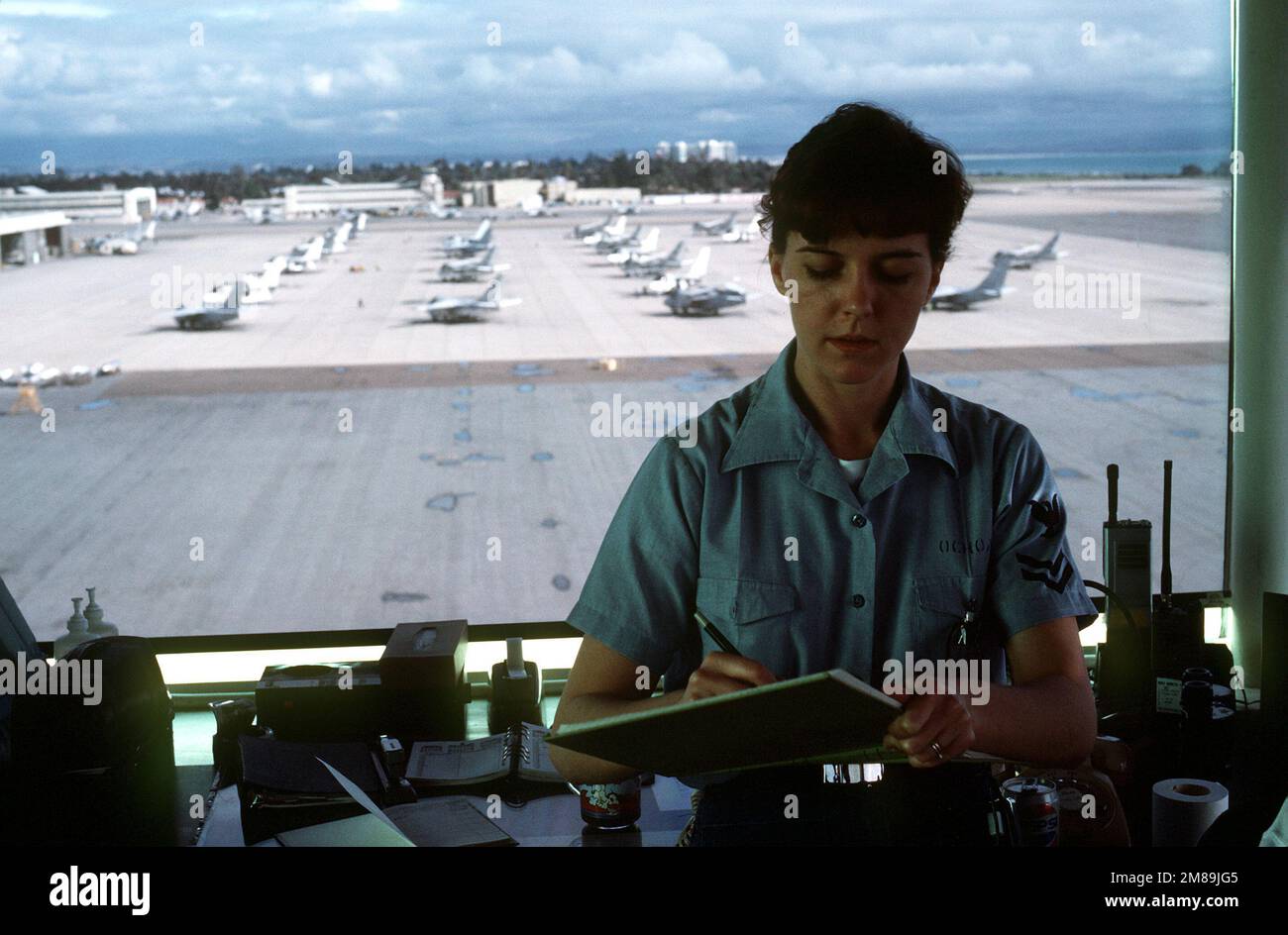 A female Navy air traffic controller makes a notation while on duty in ...