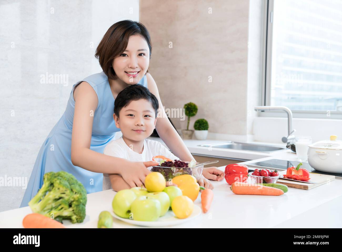 Happy mother in the kitchen cooking Stock Photo - Alamy
