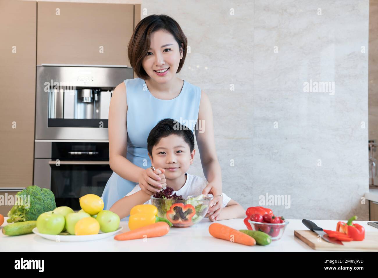 Happy mother in the kitchen cooking Stock Photo - Alamy