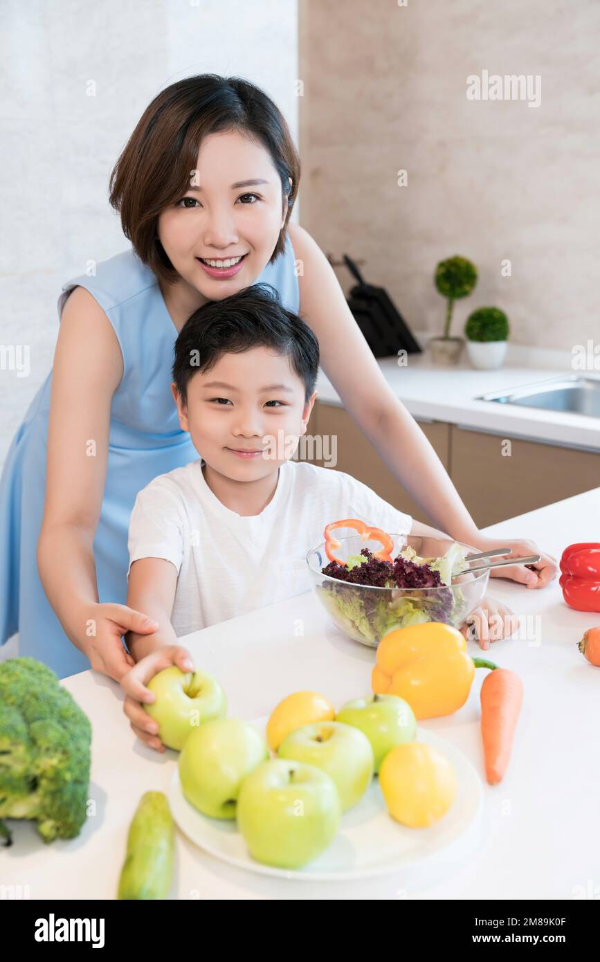 Happy mother in the kitchen cooking Stock Photo - Alamy