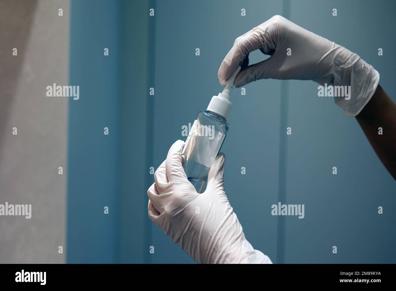 Gloved hands holding the liquid bottle in the laboratory Stock Photo ...