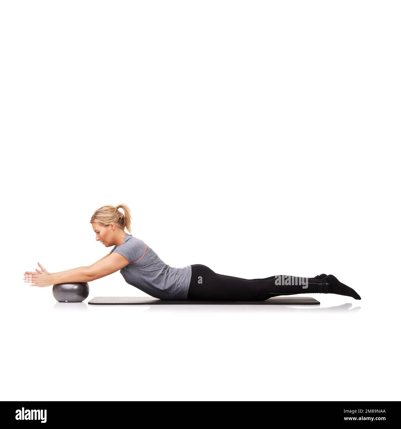 Fitness is important to her. A young woman using an exercise ball while ...