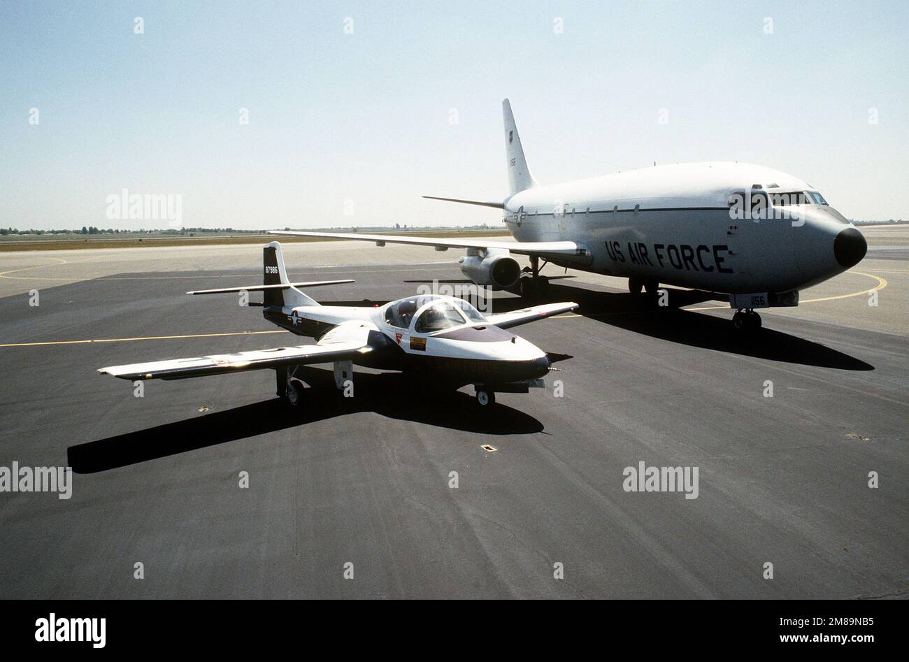A T-37 Tweet aircraft and a T-43 aircraft stand on the flight line. The ...