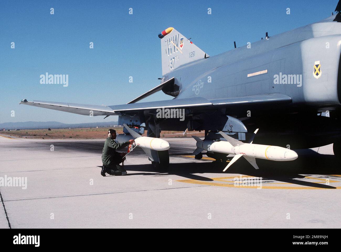 An armament technician secures AGM-88 high-speed anti-radiation missile ...