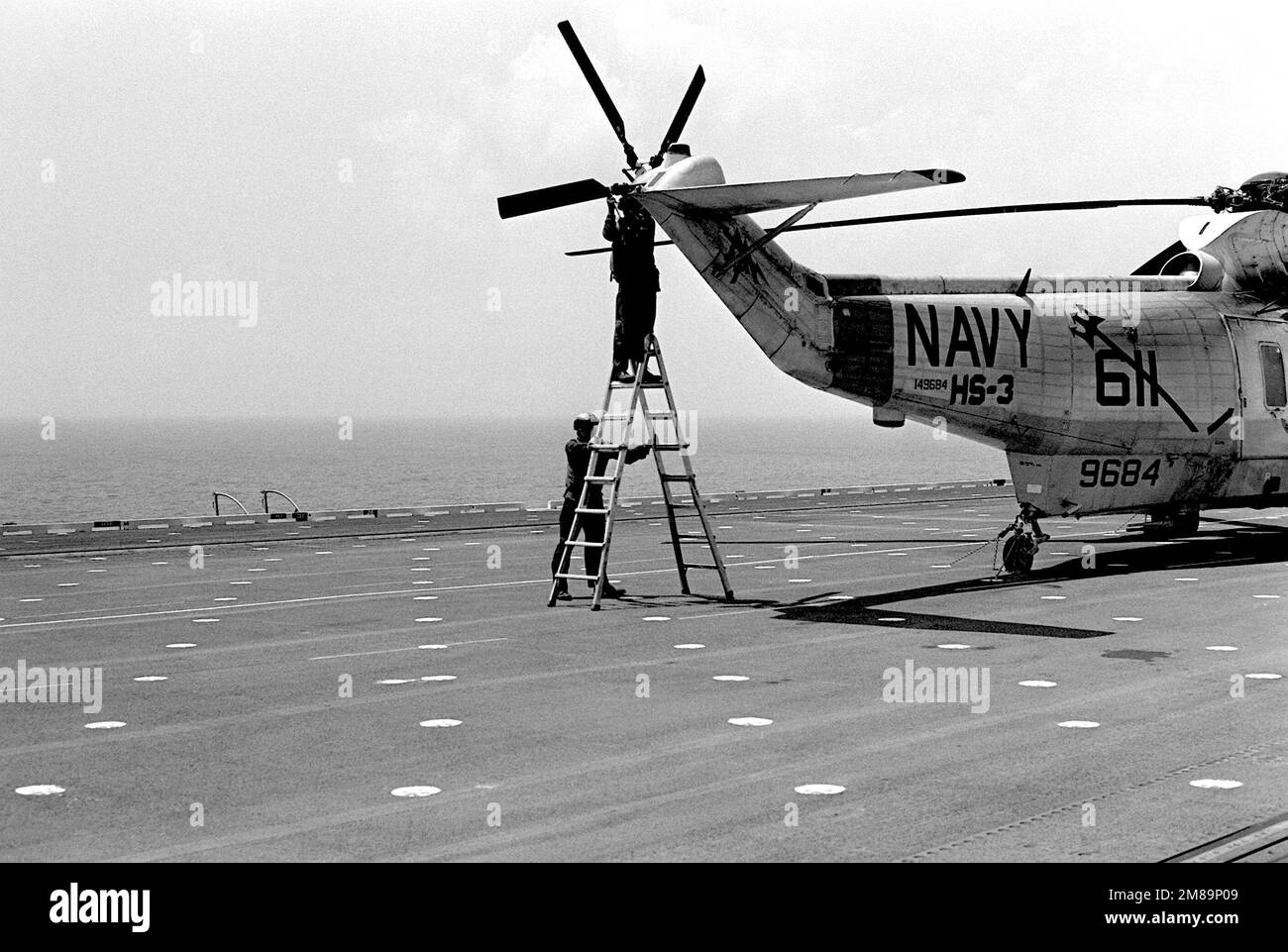 Crewmen work on the tail rotor of a Helicopter Anti-submarine Squadron ...