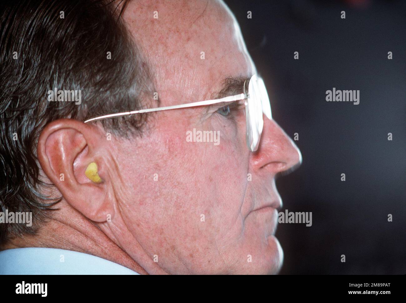 Vice President George Bush wears ear plugs while seated aboard a 4th ...