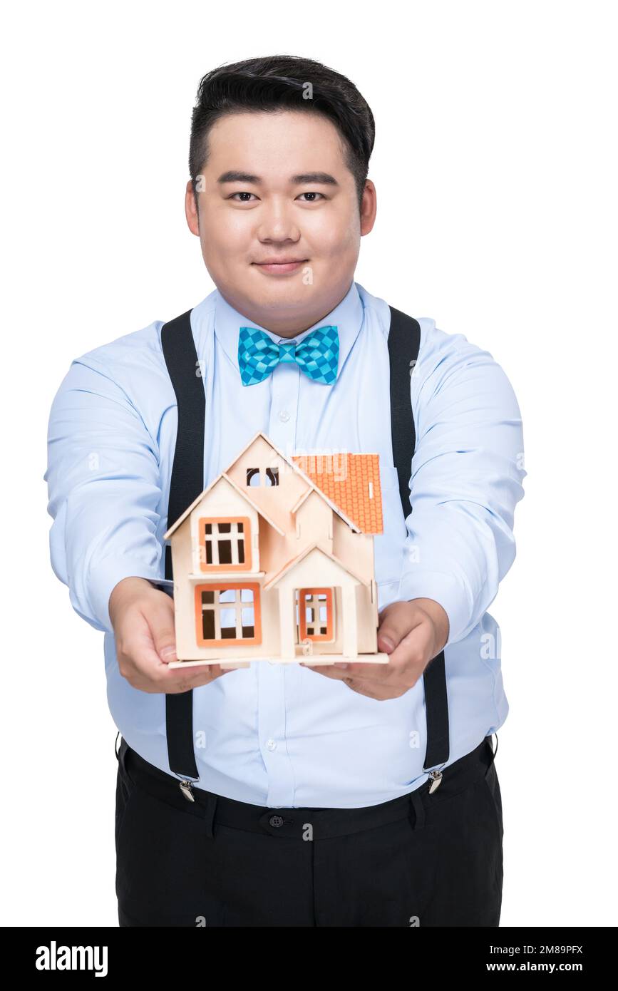 Obese young man with a house model Stock Photo - Alamy