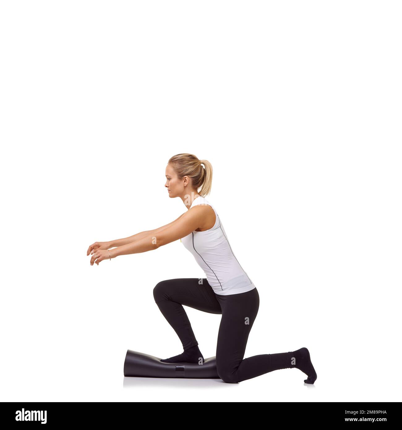Keeping her balance on her exercise mat. A pretty young woman balancing ...