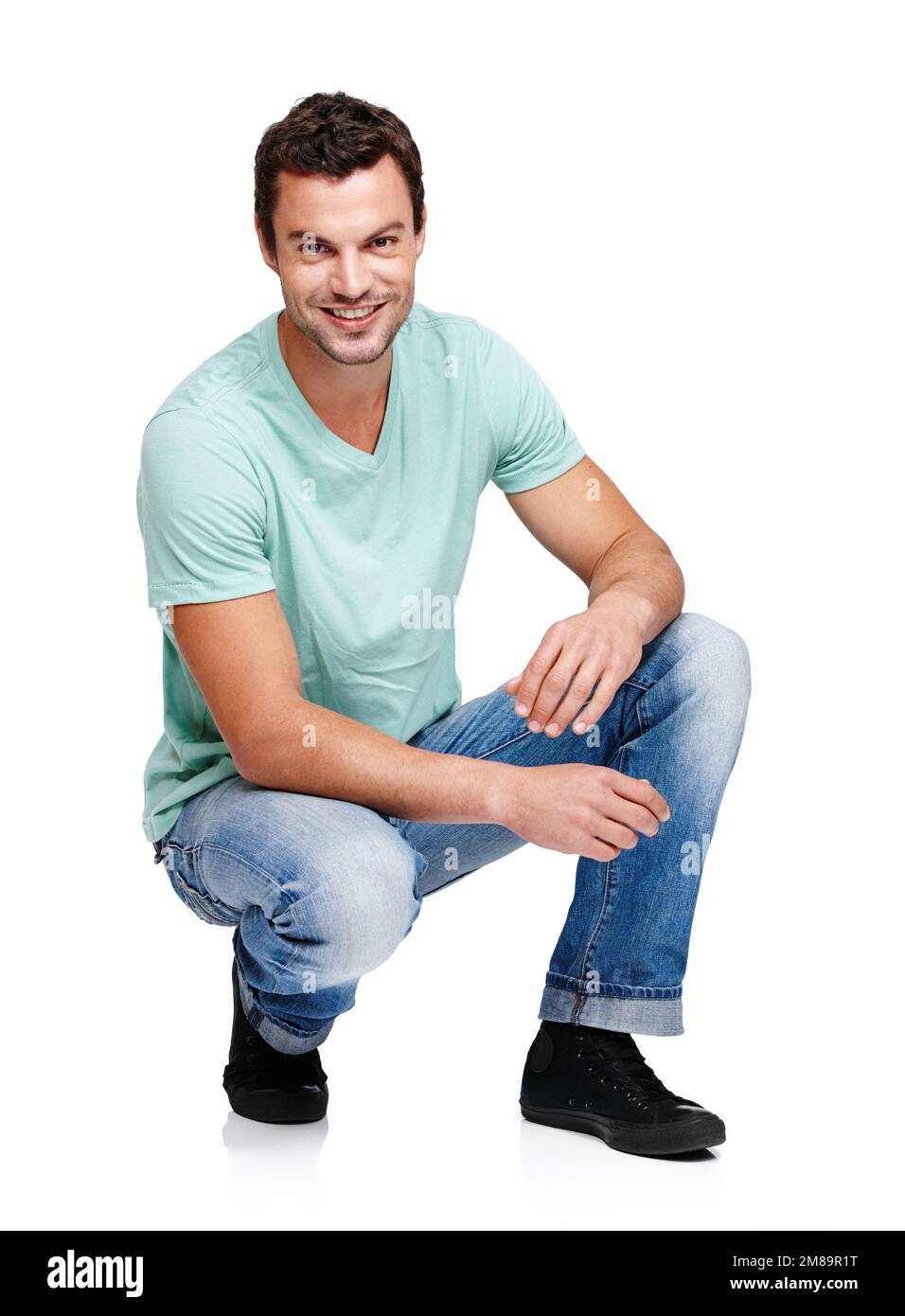 Young man crouching in studio hi-res stock photography and images - Alamy