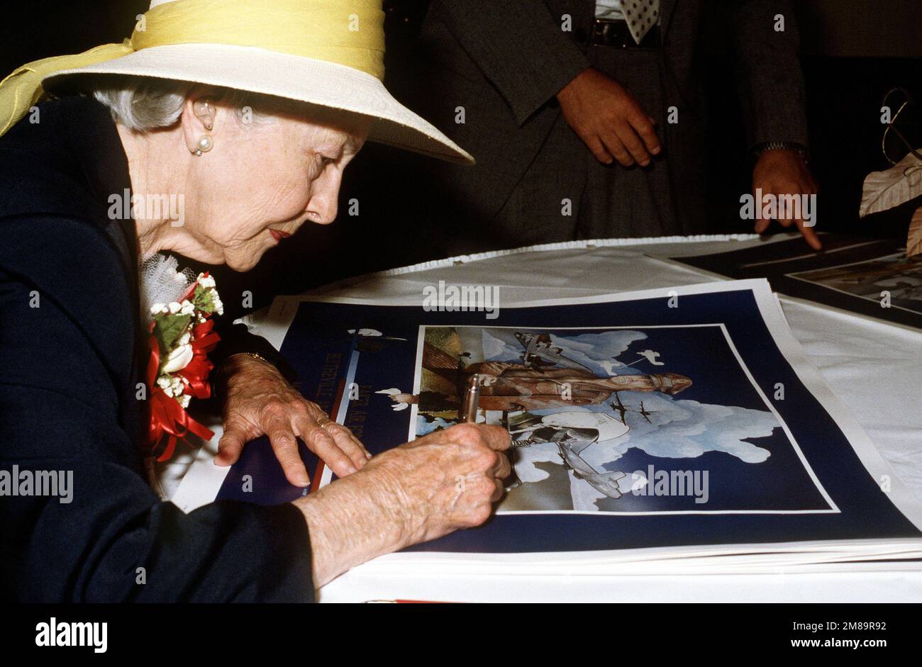 Ruth Eaker, widow of General Ira C. Eaker, signs a lithograph depicting ...