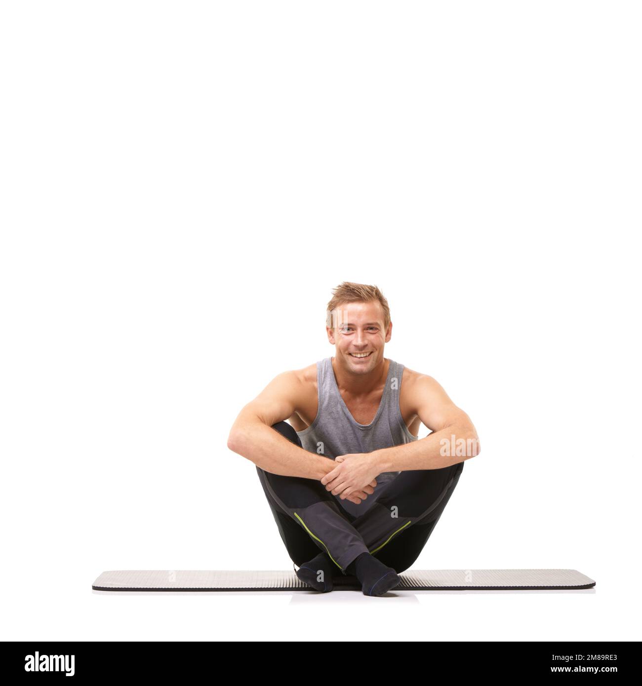Being fit brings a smile to his face. A handsome young man sitting on ...