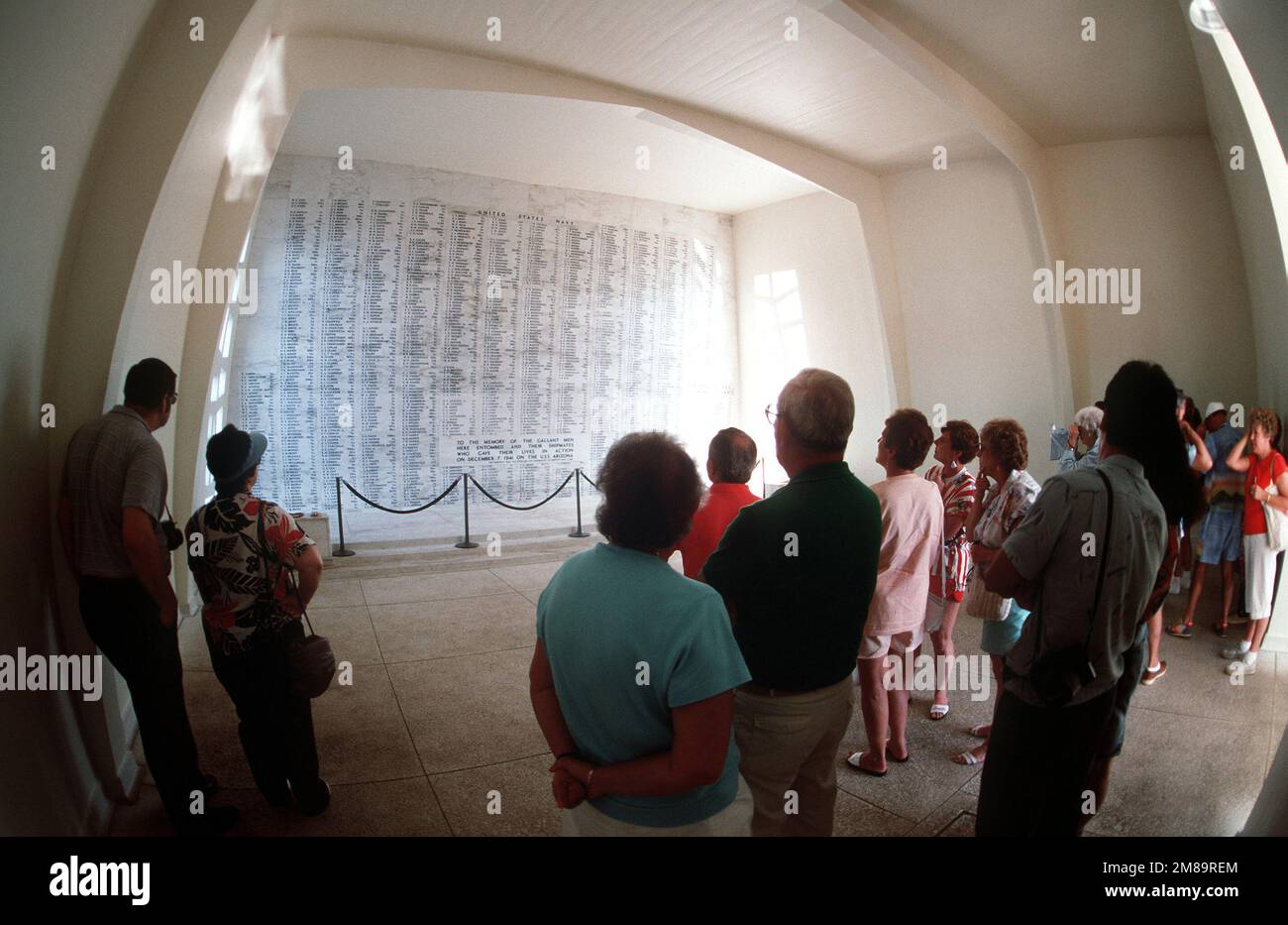 Visitors to the USS Arizona Memorial view a wall bearing the names of ...