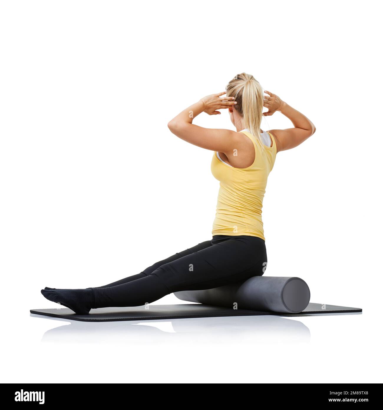 Twisting to strengthen her core. A young woman sitting on a foam roller ...