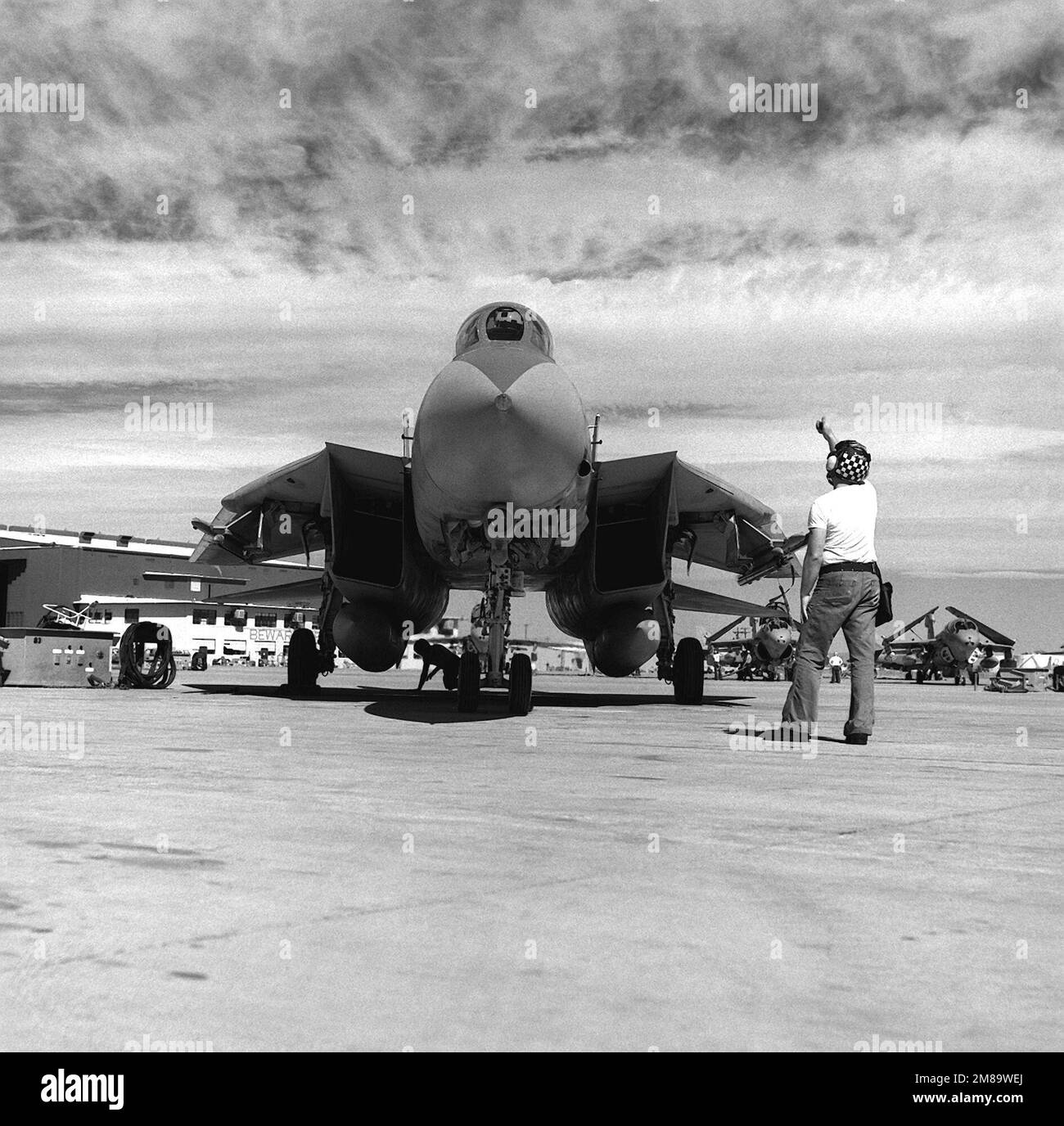 A plane captain for Fighter Squadron 33 (VF-33) signals the pilot of an ...
