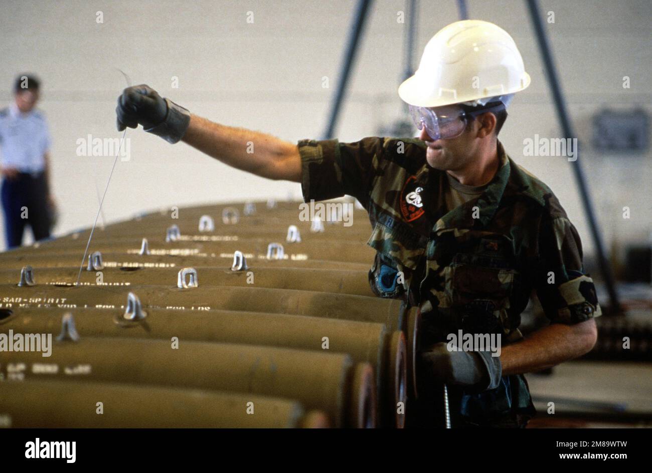 An airman pulls an arming safety wire from the center of a Mark 82 500 ...