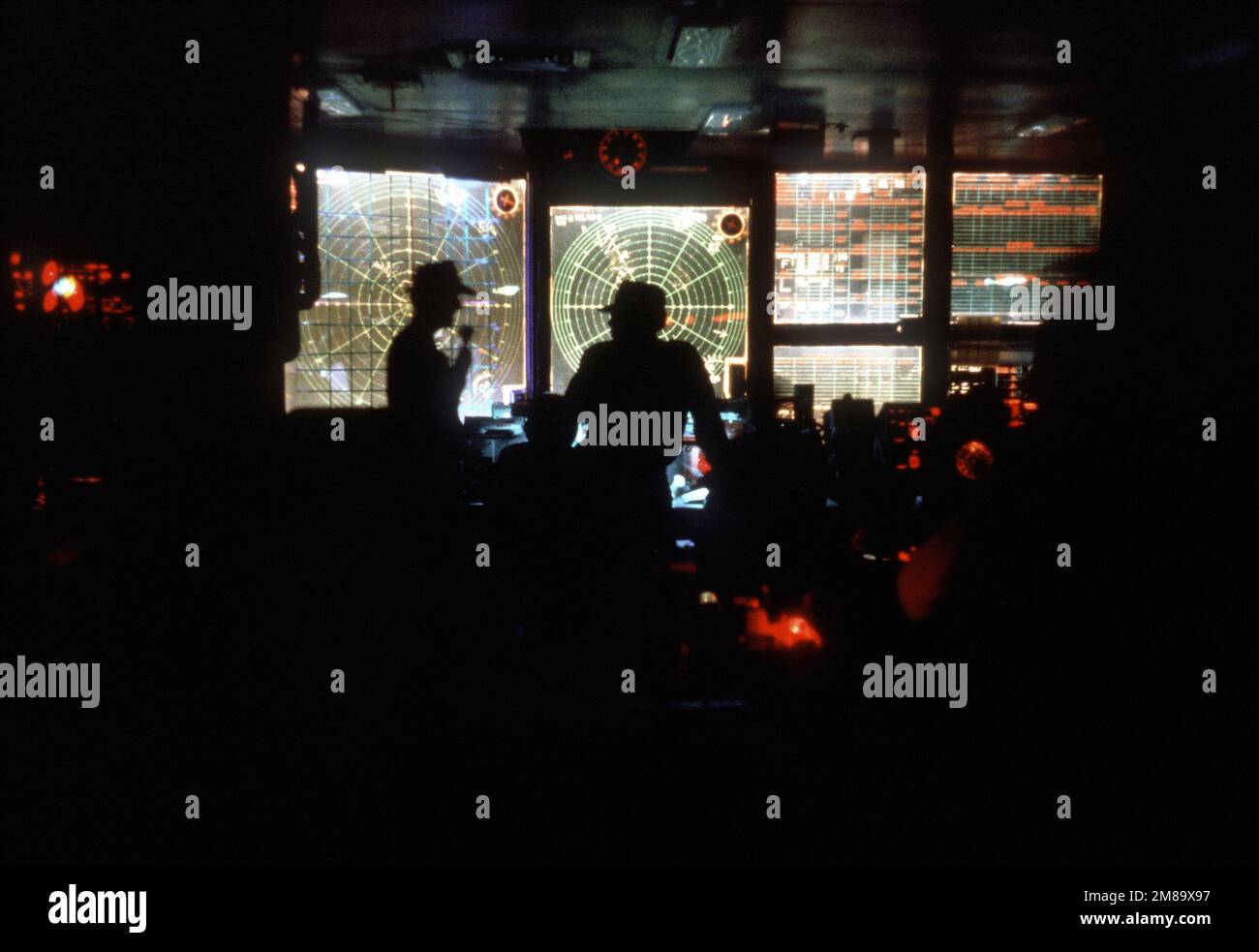 Crewmen study plotting boards in a shipboard combat information center ...