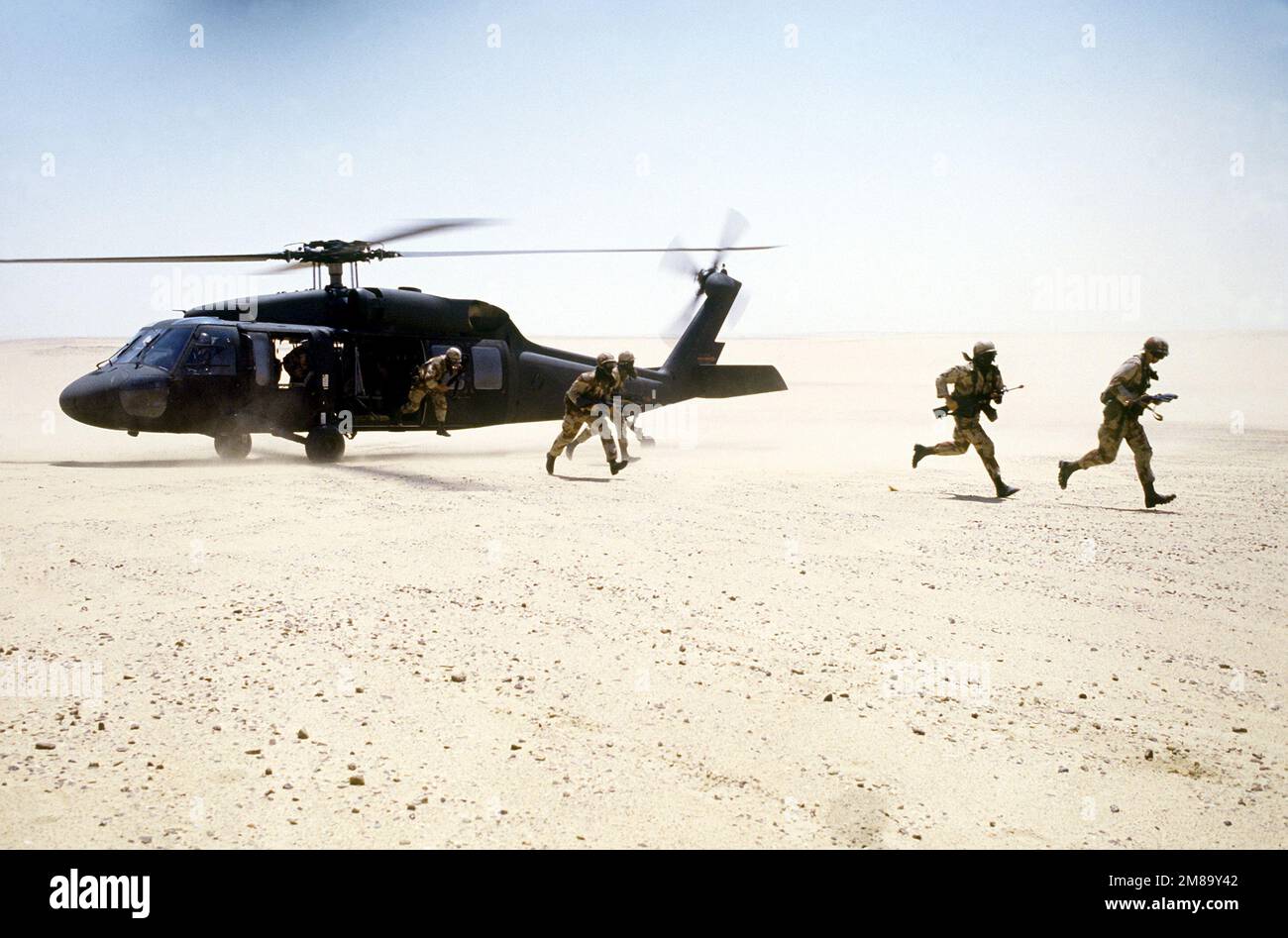 U.S. Army soldiers carrying M-16A1 rifles sprint from a UH-60 Black ...