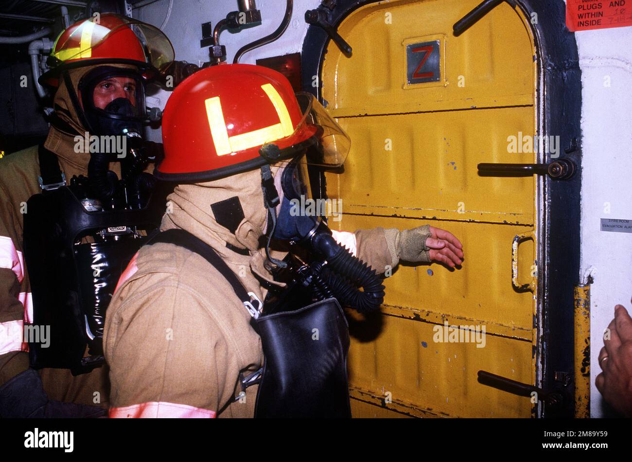 Firefighters aboard the battleship USS MISSOURI (BB-63) wears an A-4 ...