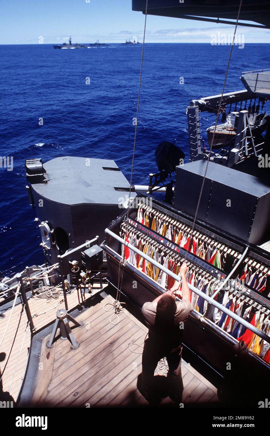A signalman aboard the battleship USS MISSOURI (BB-63) hoists signal ...