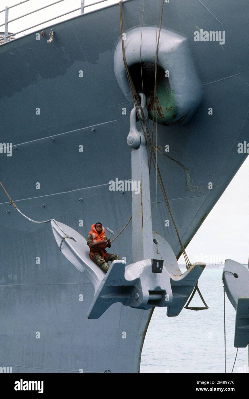 A crew member paints the anchor of the battleship USS MISSOURI (BB-63 ...