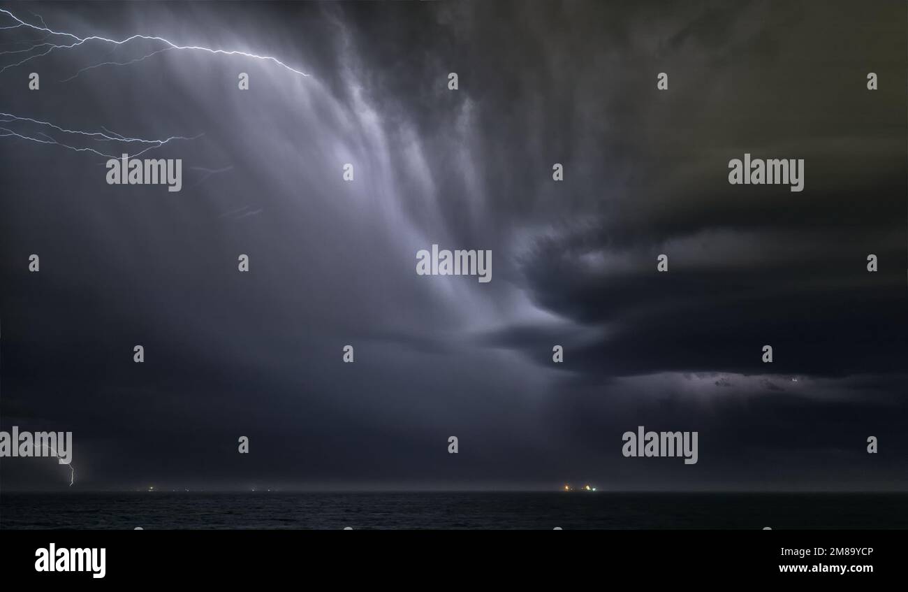 Thundercloud with lightning at night over the ocean Stock Photo - Alamy