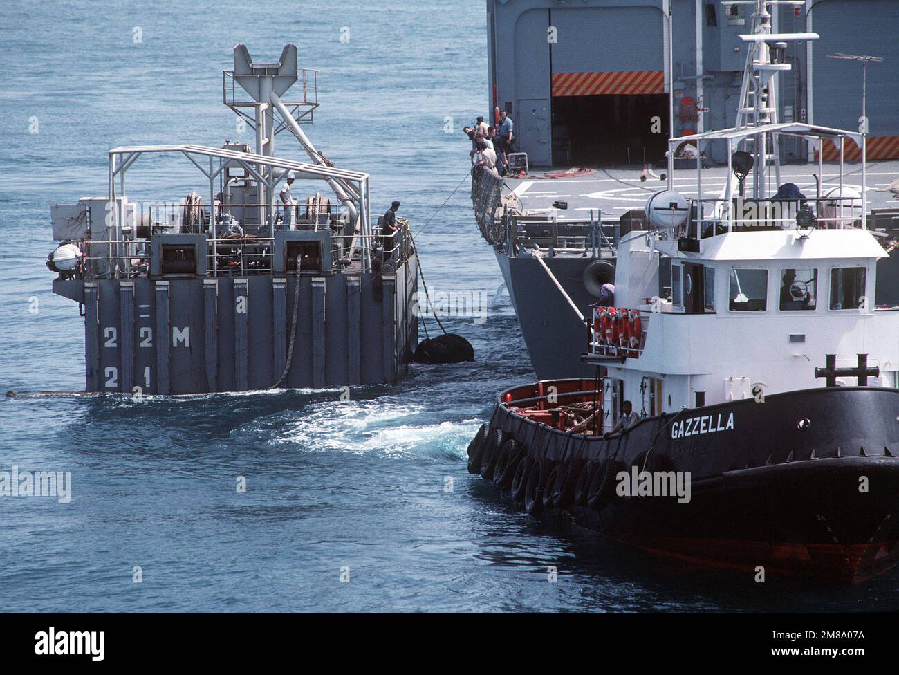 A civilian tug maneuvers the guided missile frigate USS SAMUEL B ...