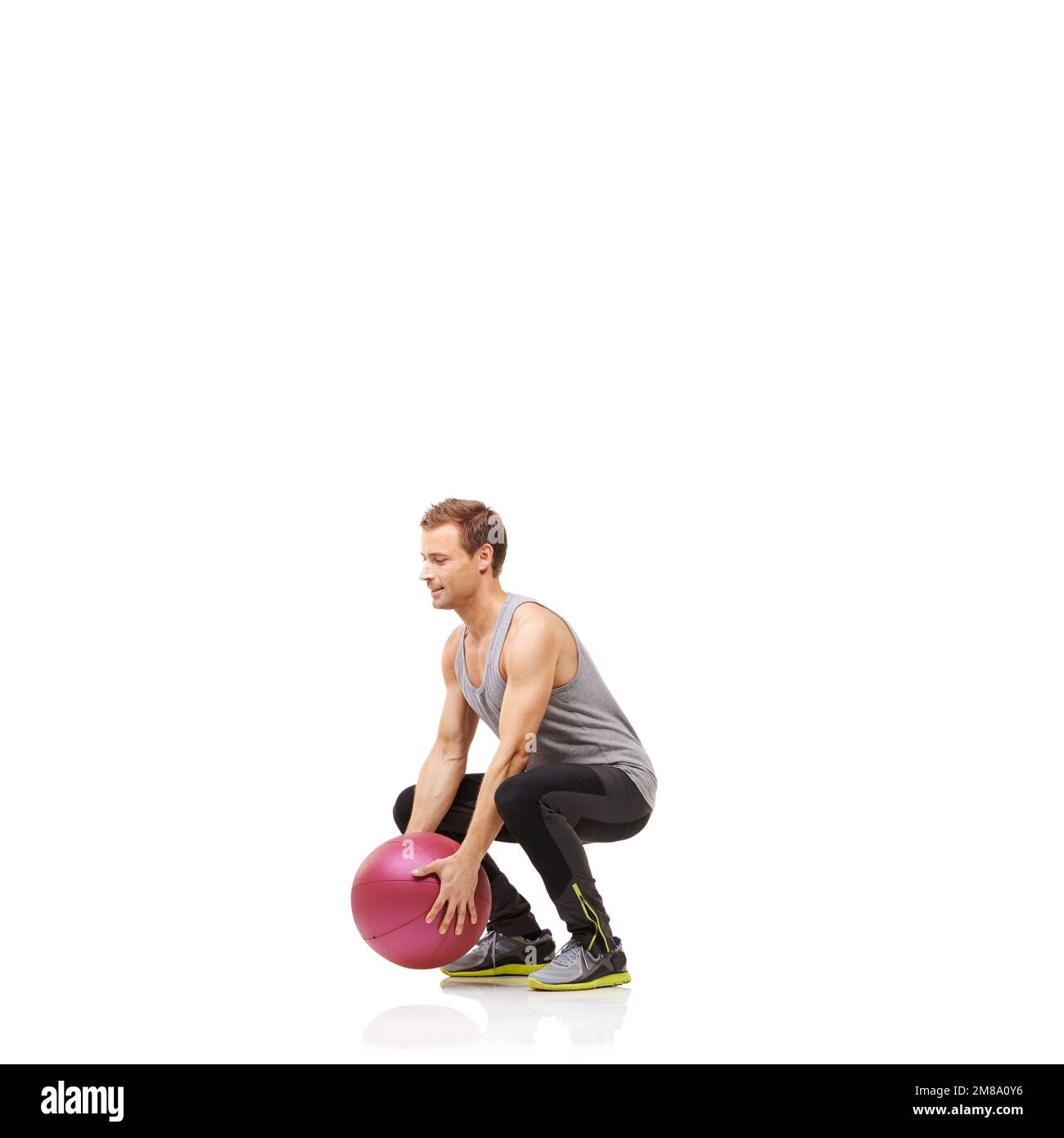 Toning up his legs. A young man working out with a medicine ball on a ...