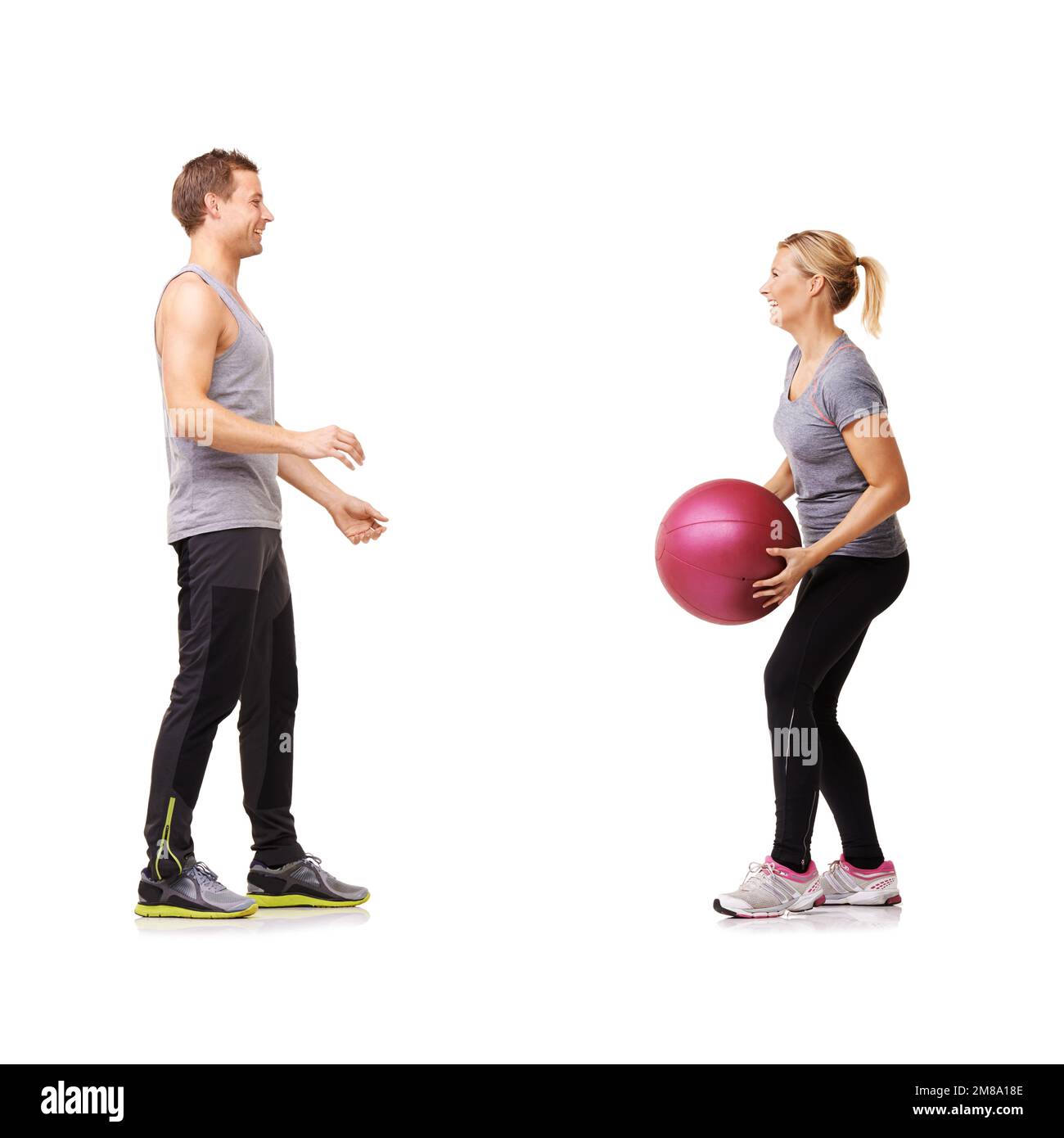 Helping him tone up. A man and woman exercising by throwing a medicine ...