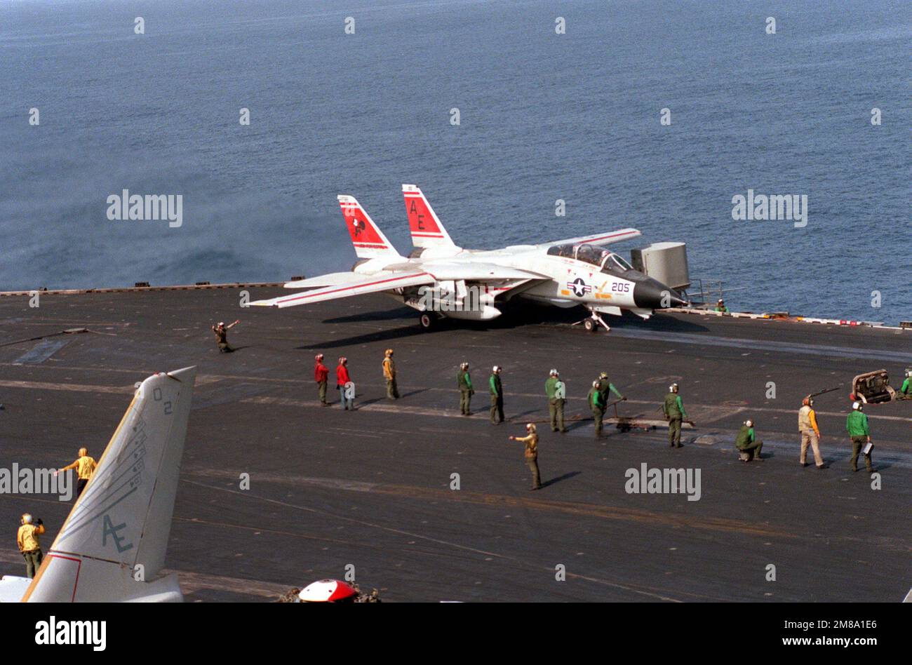Flight deck crewmen watch as the catapult crew prepares to launch a ...