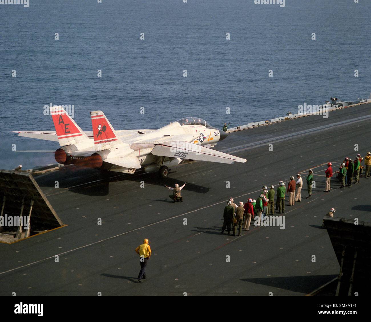 Crewmen watch as the catapult crew prepares to launch a Fighter ...