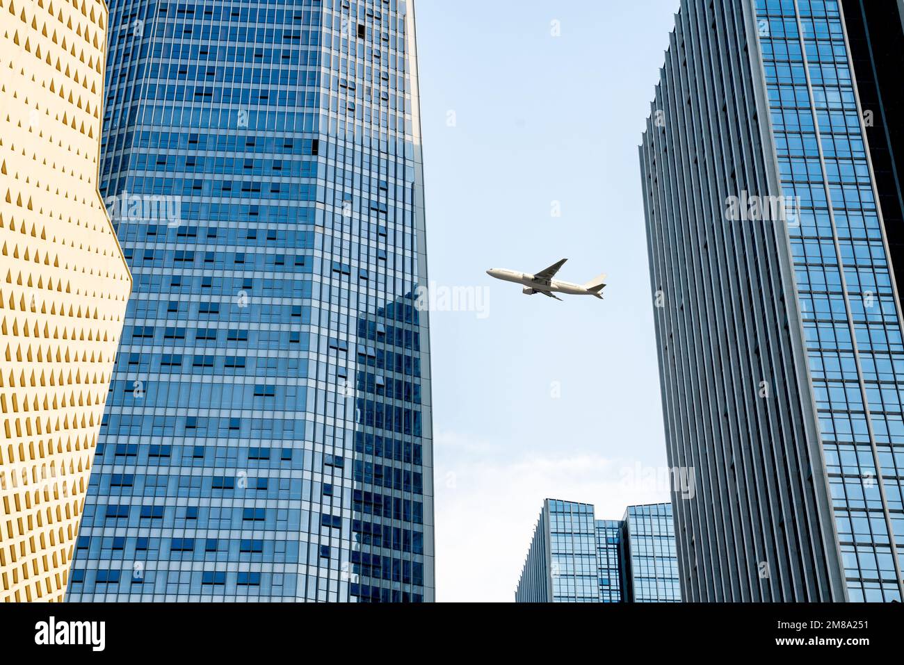 An airplane fly over modern office buildings in downtown Stock Photo ...