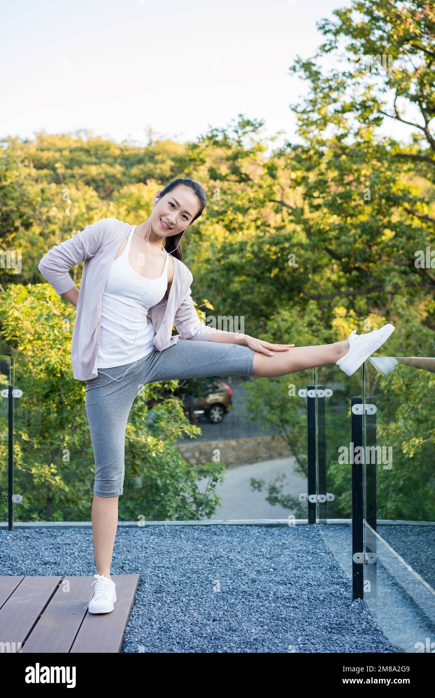 A young woman to listen to music while exercising Stock Photo - Alamy