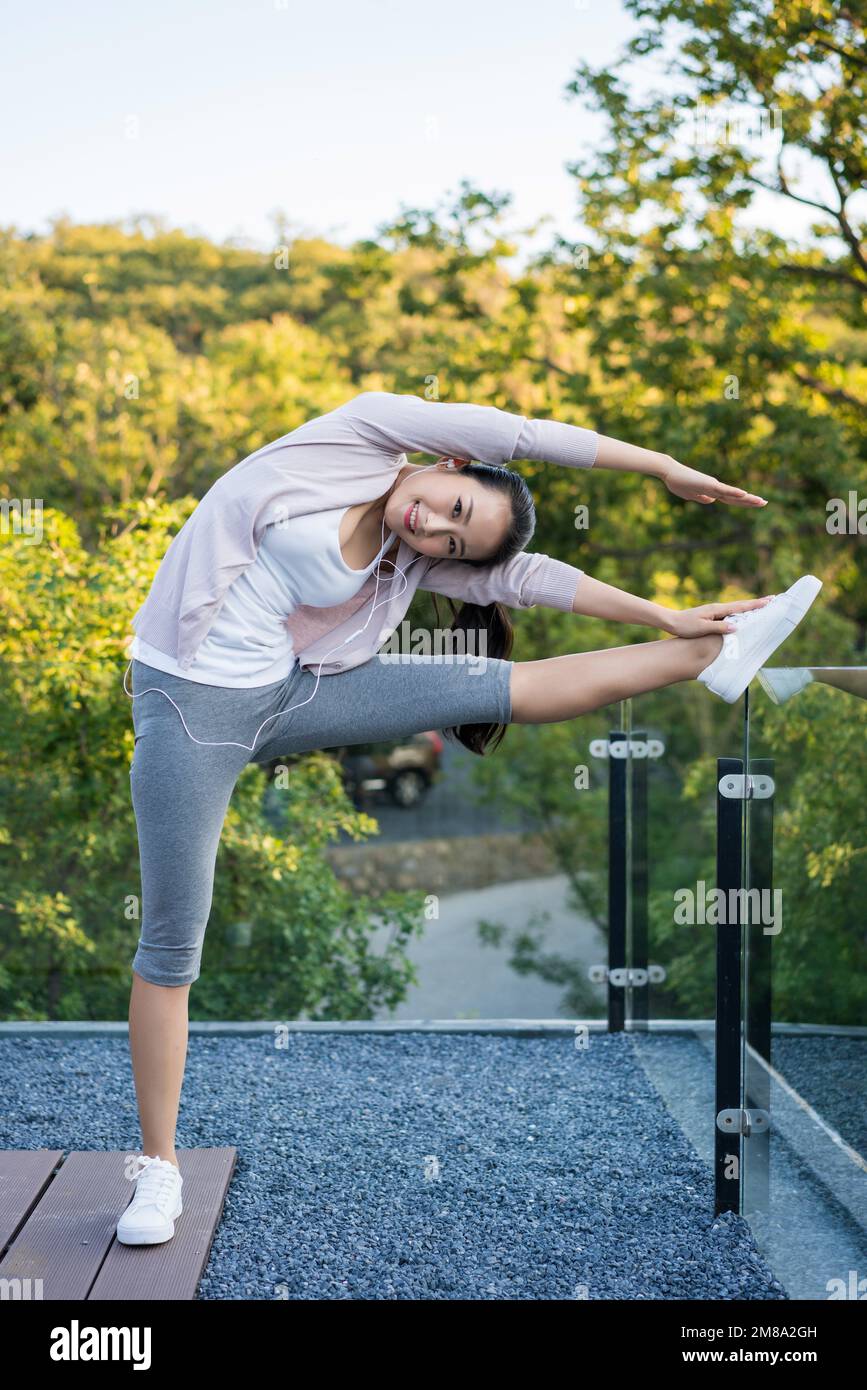 A young woman to listen to music while exercising Stock Photo - Alamy