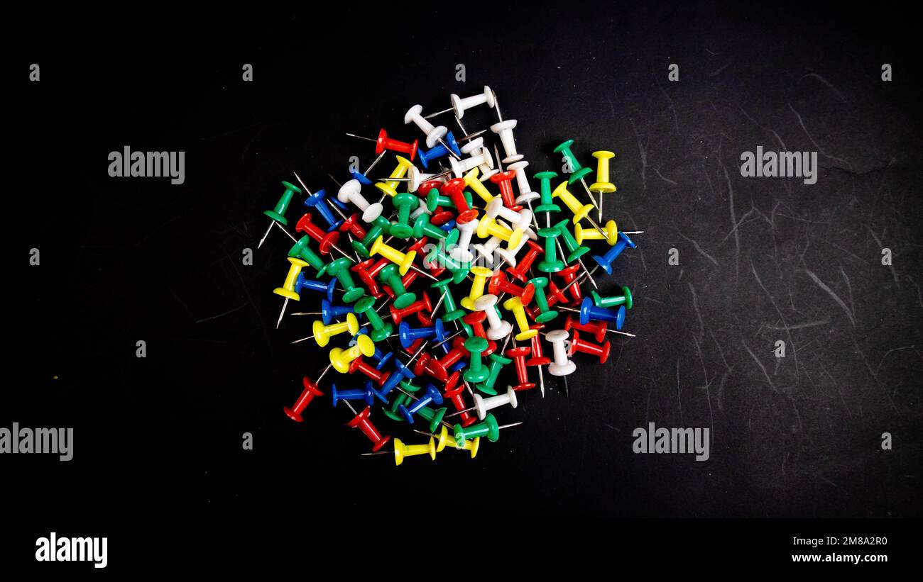 colorful thumbtacks on black background Stock Photo - Alamy
