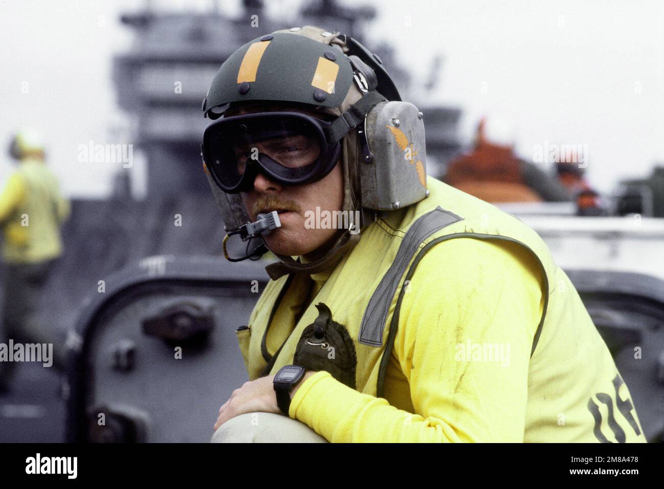 A plane director observes operations on the flight deck of the aircraft ...