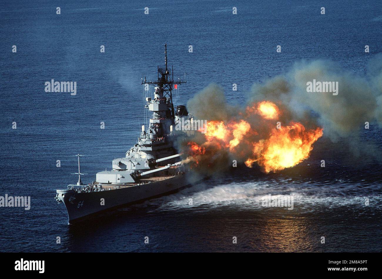 A port bow view of the battleship WISCONSIN (BB-64) firing its Mark 7 ...