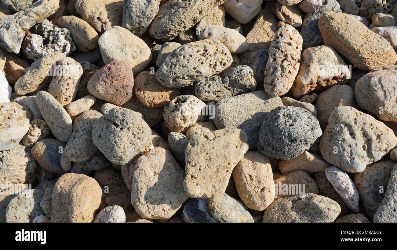 Cobble pieces of marble rock near water edge in Caesarea Maritima ...