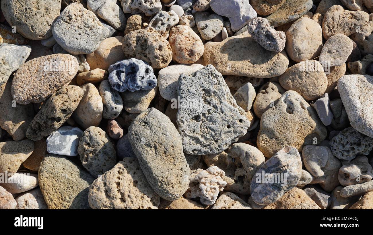 Cobble pieces of marble rock near water edge in Caesarea Maritima ...