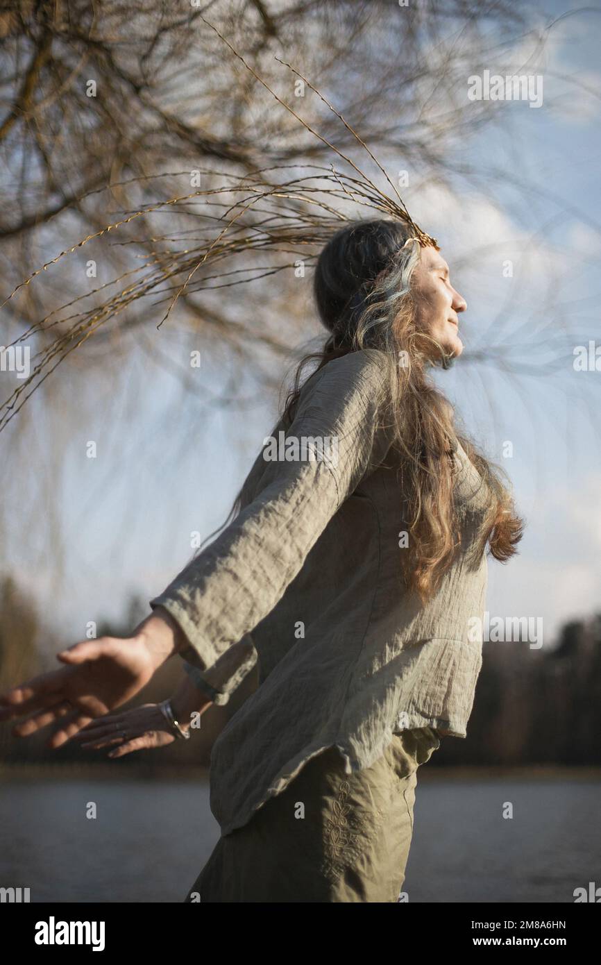 Close up authentic woman with willow crown enjoying warm sunlight ...