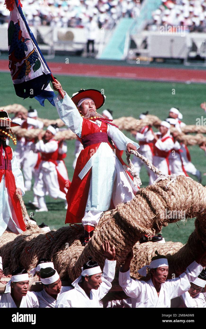 An ornately dressed Korean holds a flag in a ceremony at the XXIVth ...
