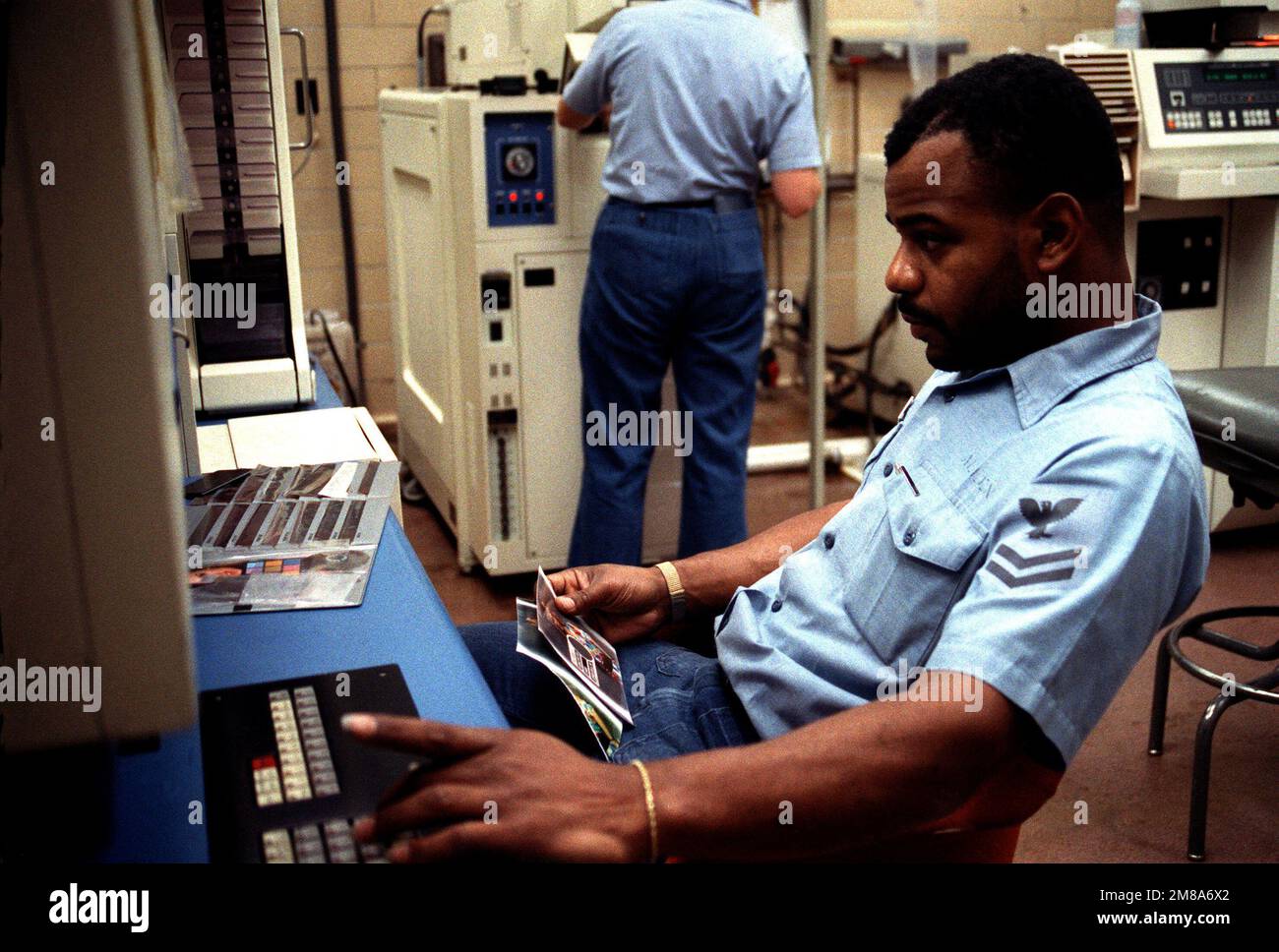 A photographer's mate uses a mini-printer to determine color balance at ...